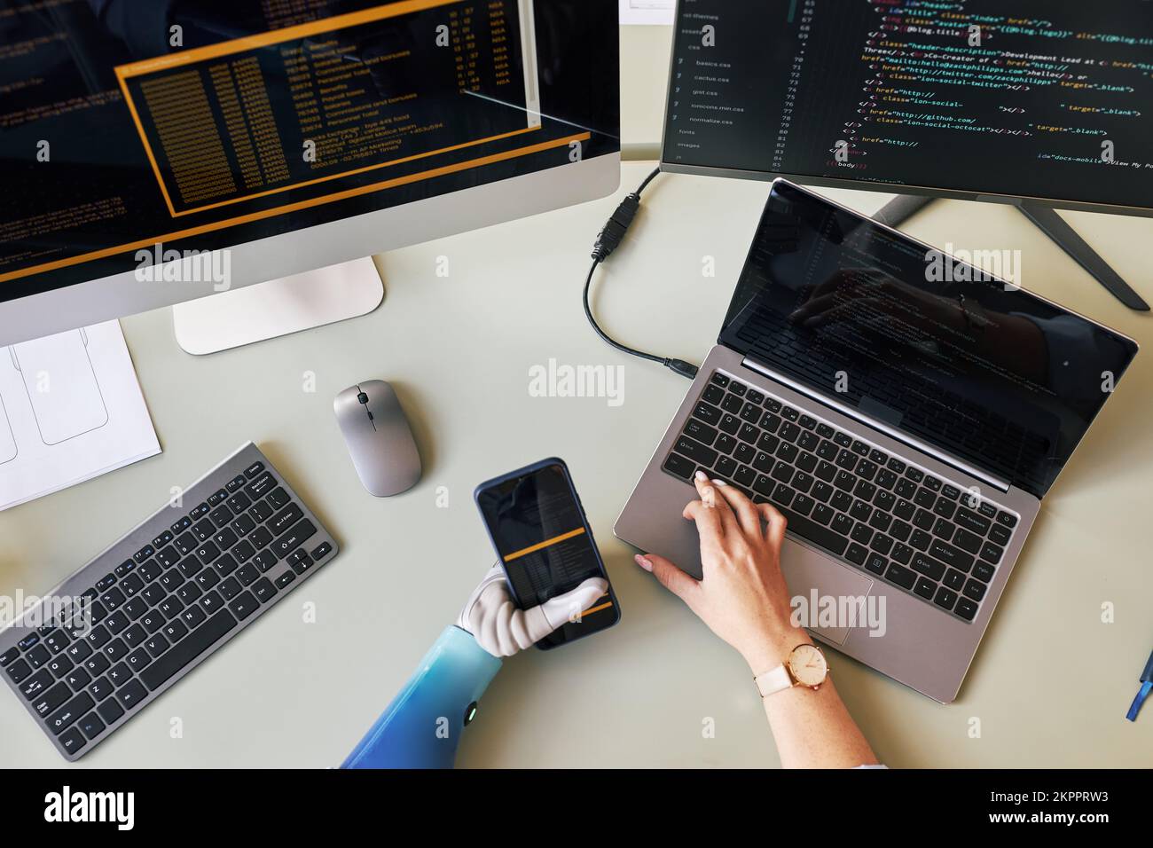 Female software developer with one prosthetic arm working on new mobile ...