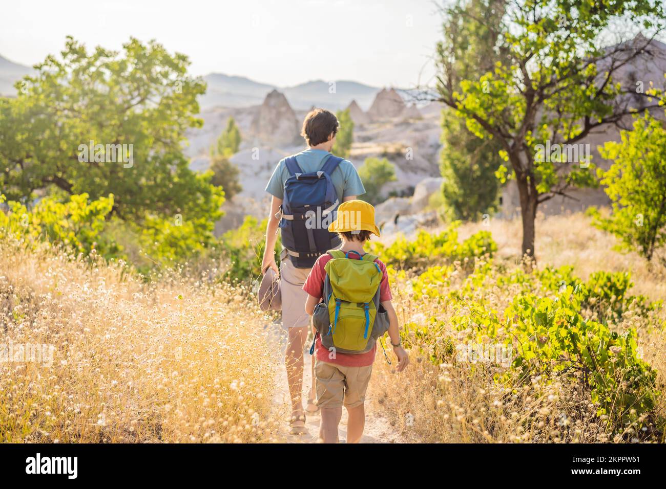 Father and son tourists exploring valley with rock formations and fairy ...