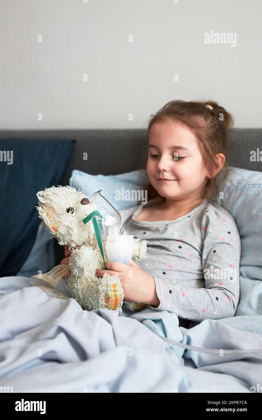 Sick child recovering in bed. Little girl playing by applying medical ...