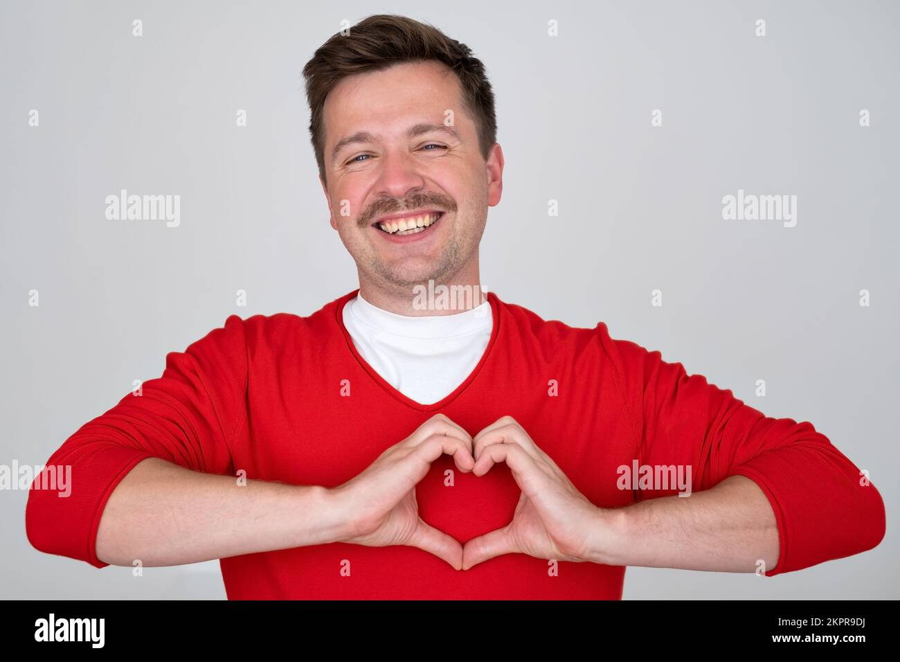 Young handsome man in love doing heart symbol shape with hands Stock ...