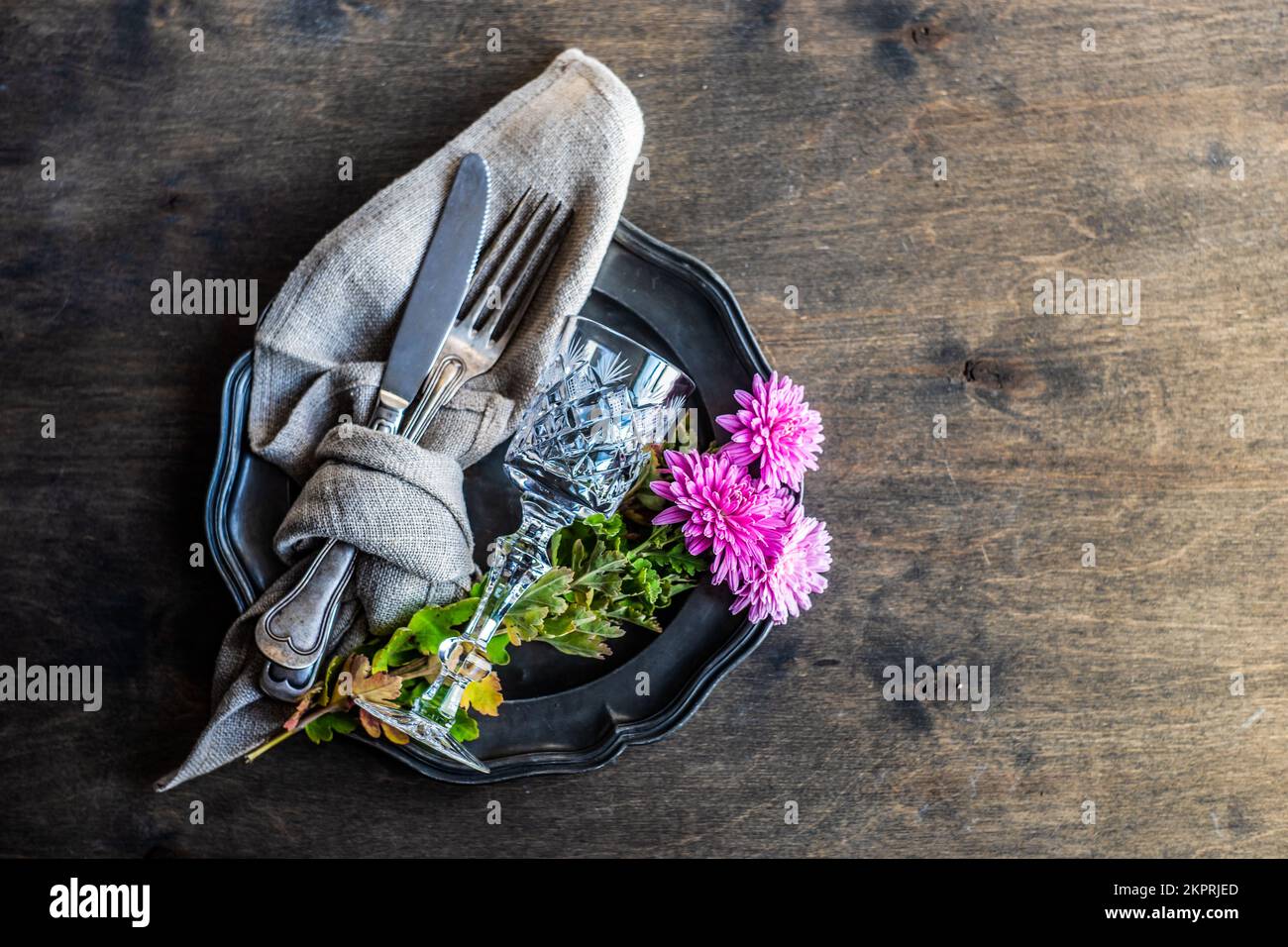 Overhead view of an autumnal place setting with a wine glass and purple ...
