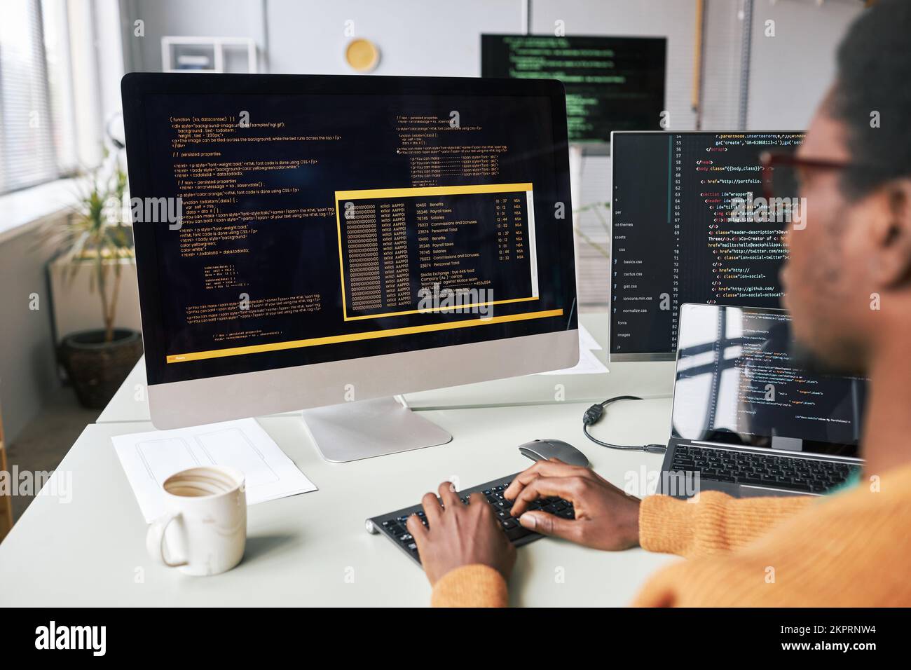 Screen with programming code in front on young software developer Stock ...
