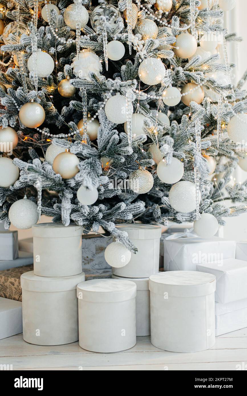 Pile of gift boxes near beautiful Christmas tree indoors Stock Photo ...