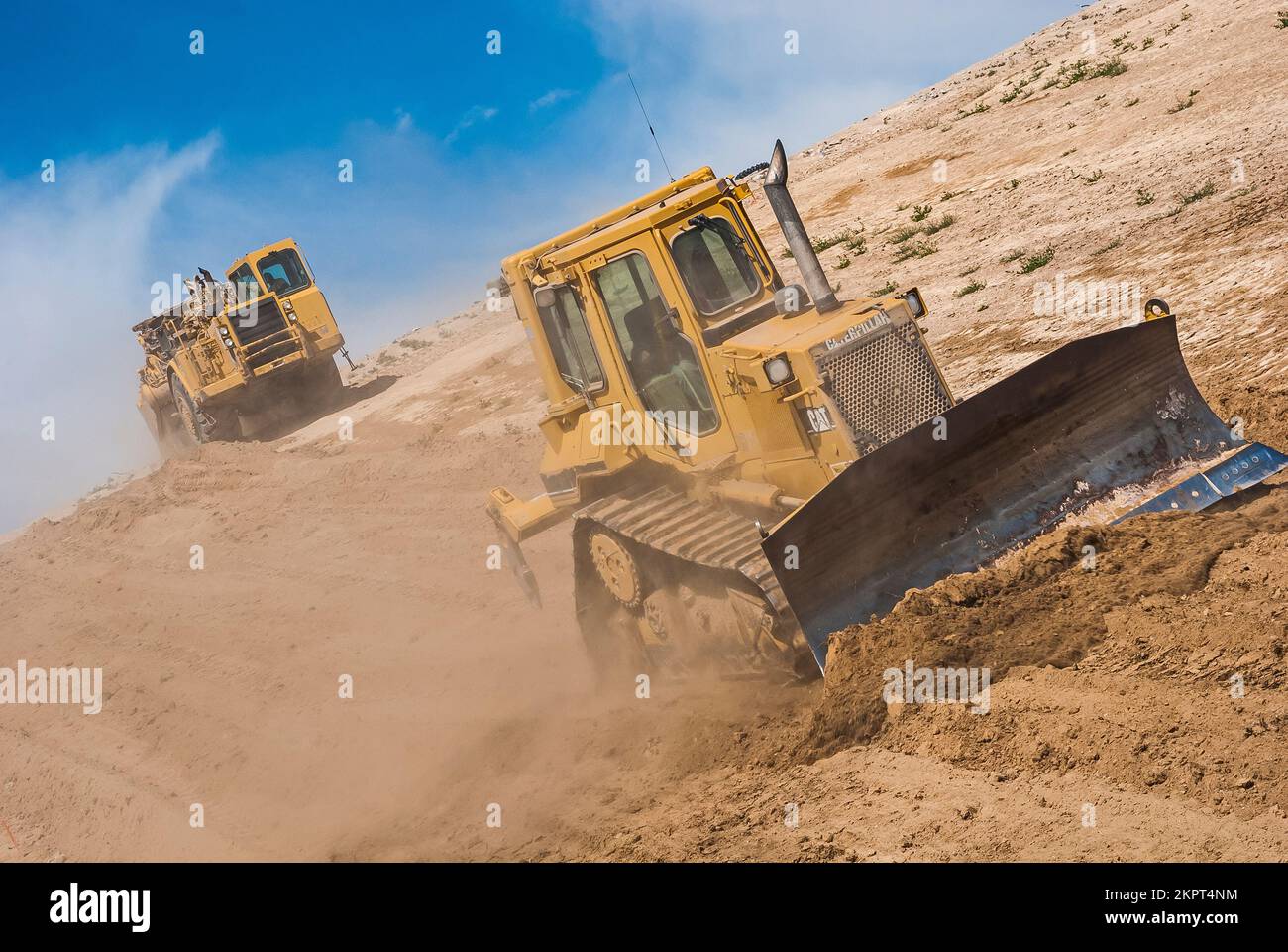 Caterpillar heavy equipment working at an active landfill in dusty ...