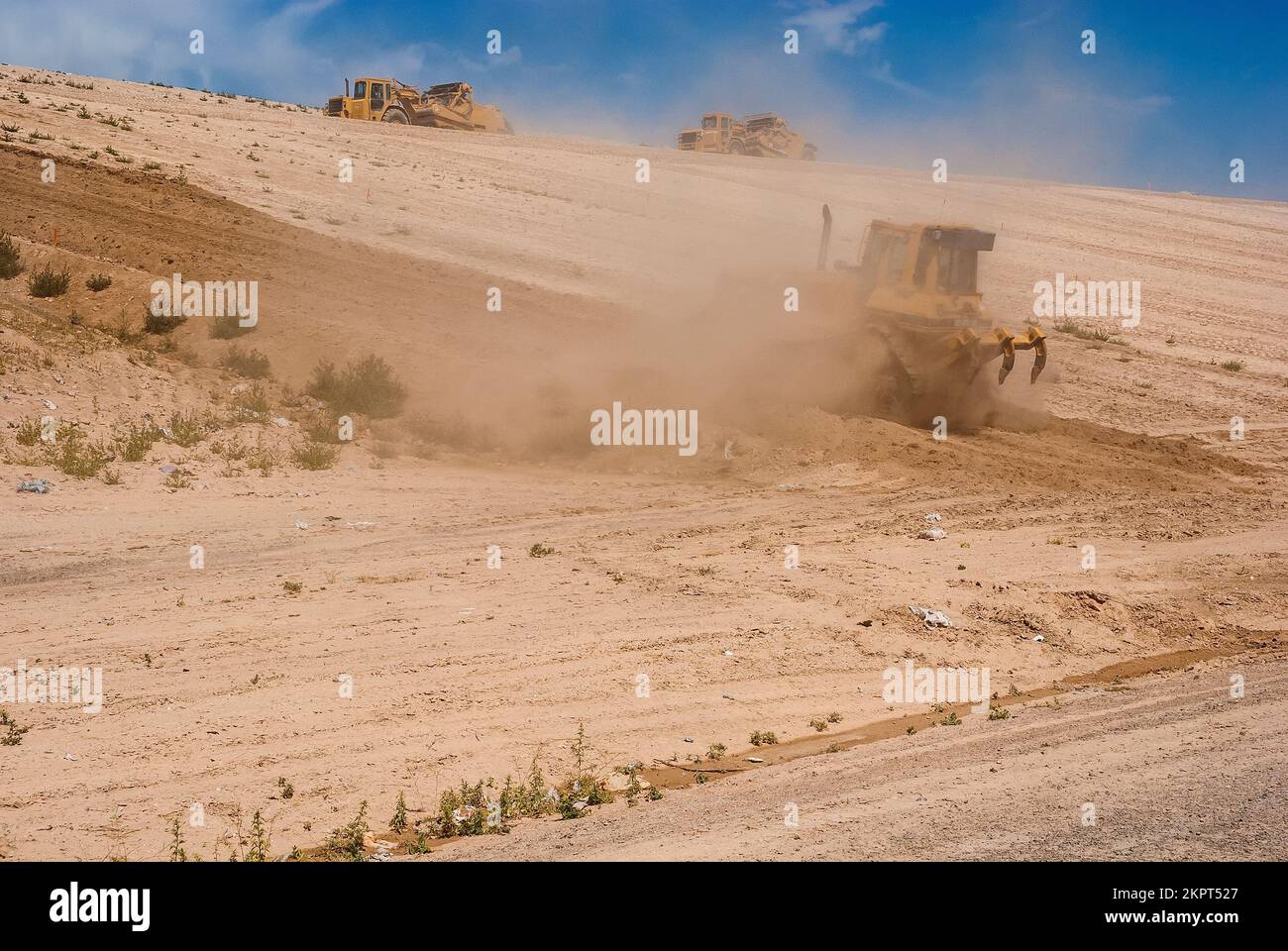 Caterpillar heavy equipment working at an active landfill in dusty ...