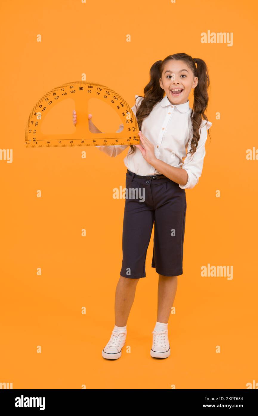 Schoolgirl holding protractor for lesson. Little child preparing for ...