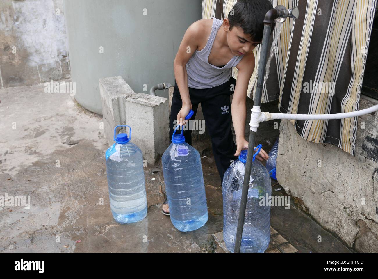 A Syrian child draws water in a street of Beirut, Lebanon, November 28 ...
