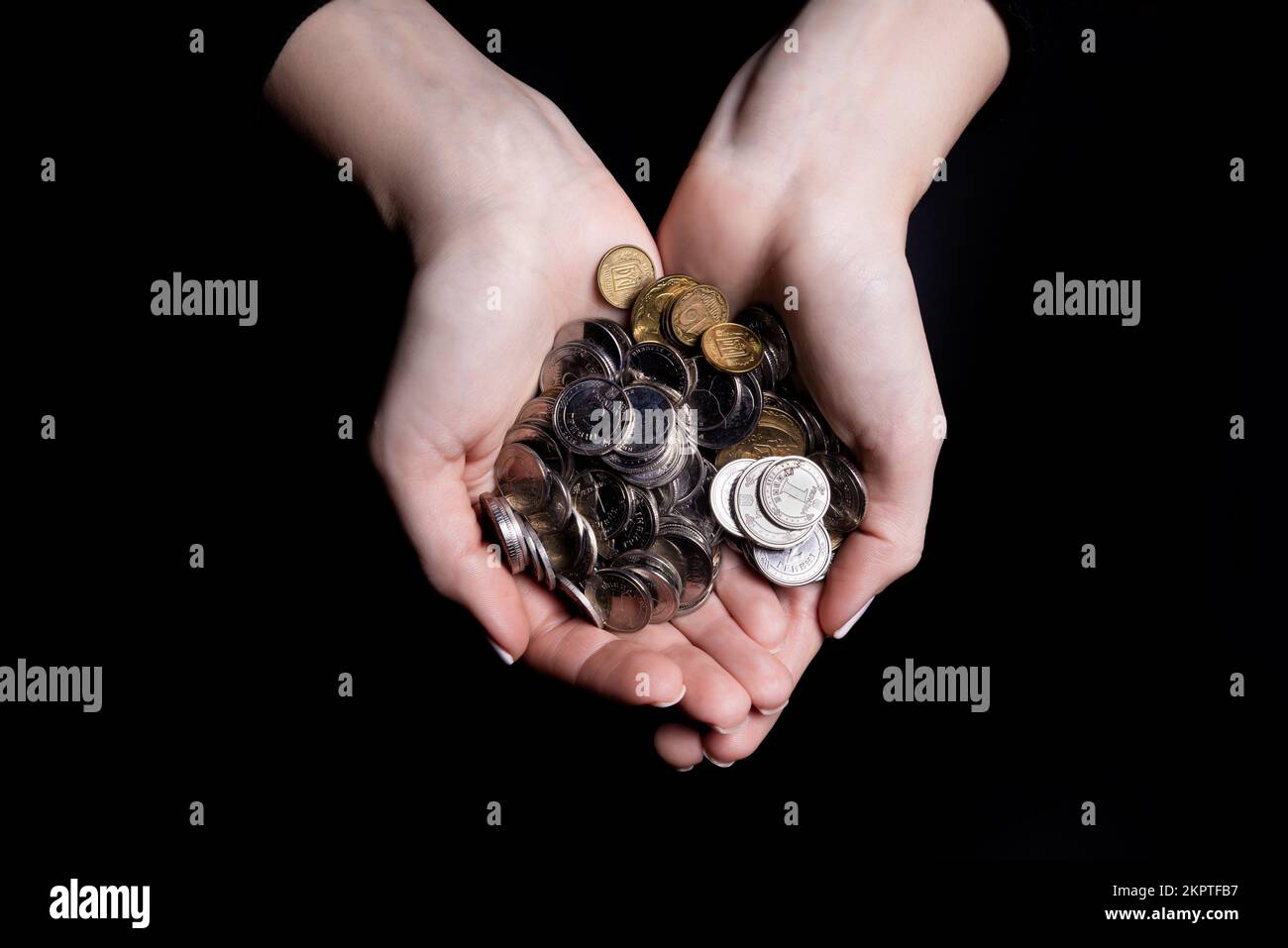 hands holding coins selective and soft focus isolated on black ...