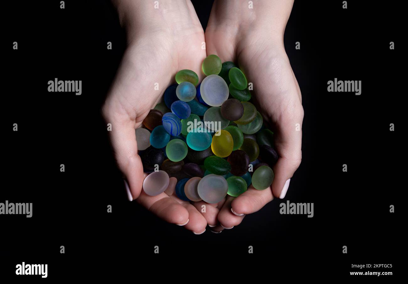 hands with colored stones Young woman is holding a collection of ...