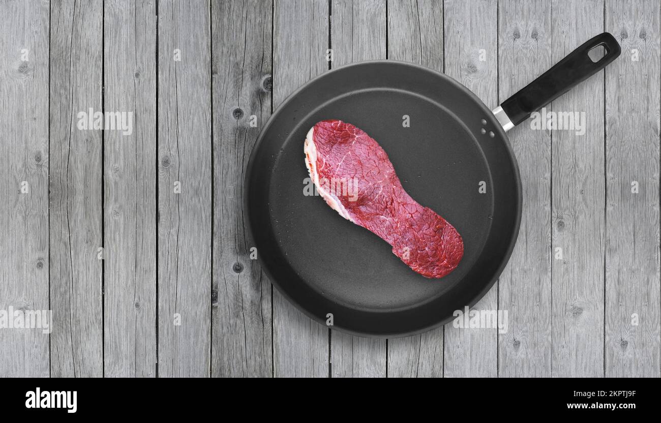 Cut of meat in the shape of shoe sole on pan. Poor quality meat concept ...