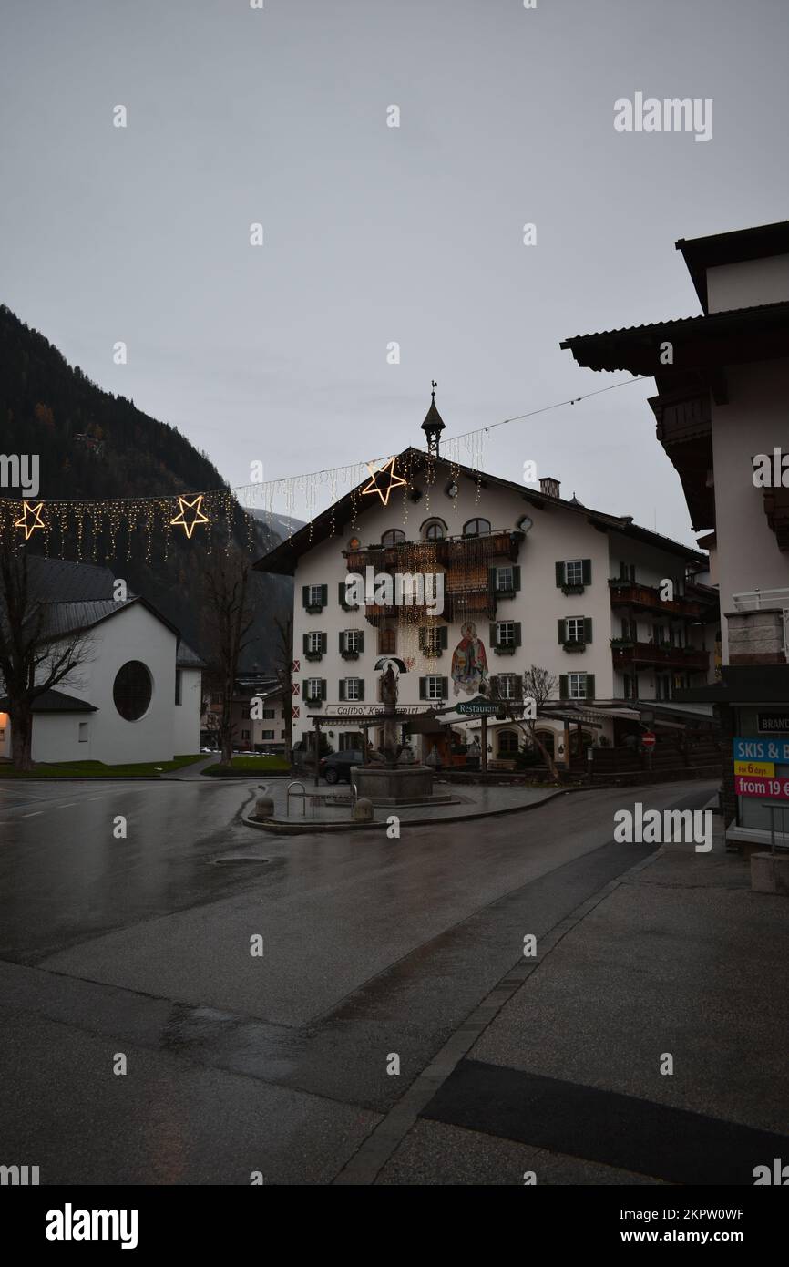 Church and the pub in small Austrian village in Alps on a rainy day ...
