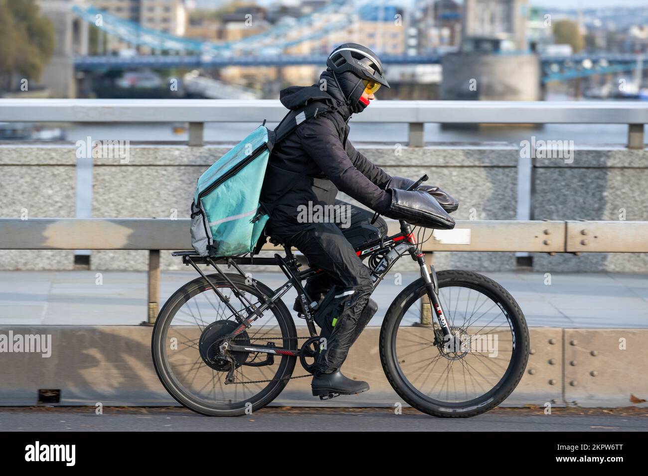 A deliveroo cycle courier riding an e-bike across, London Bridge, London, UK. 17 Nov 2022 Stock ...