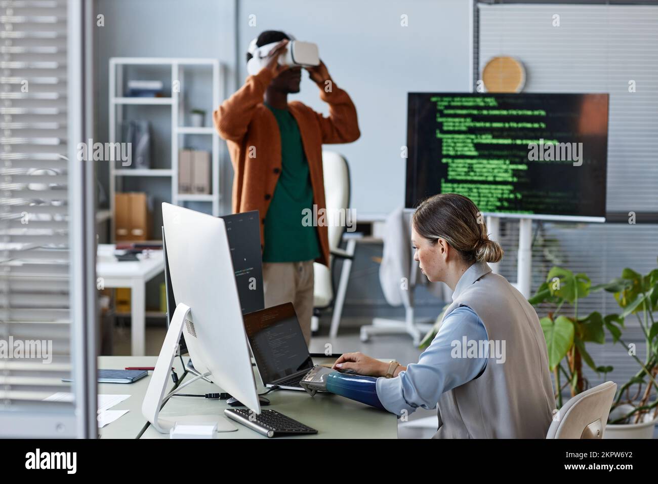 Developer with bionic arm creating software for VR headset Stock Photo - Alamy