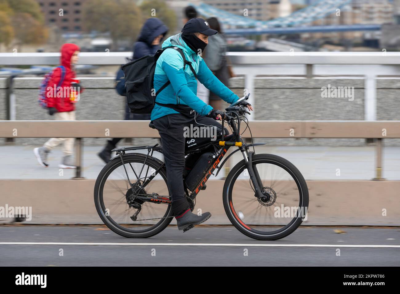 A deliveroo cycle courier riding an e-bike across, London Bridge, London, UK. 17 Nov 2022 Stock ...