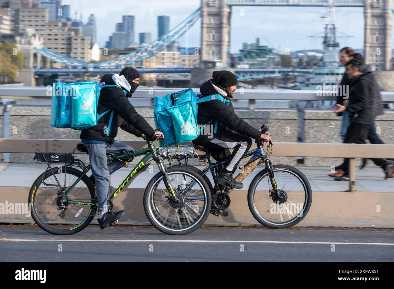 A deliveroo cycle courier riding an e-bike across, London Bridge, London, UK. 17 Nov 2022 Stock ...