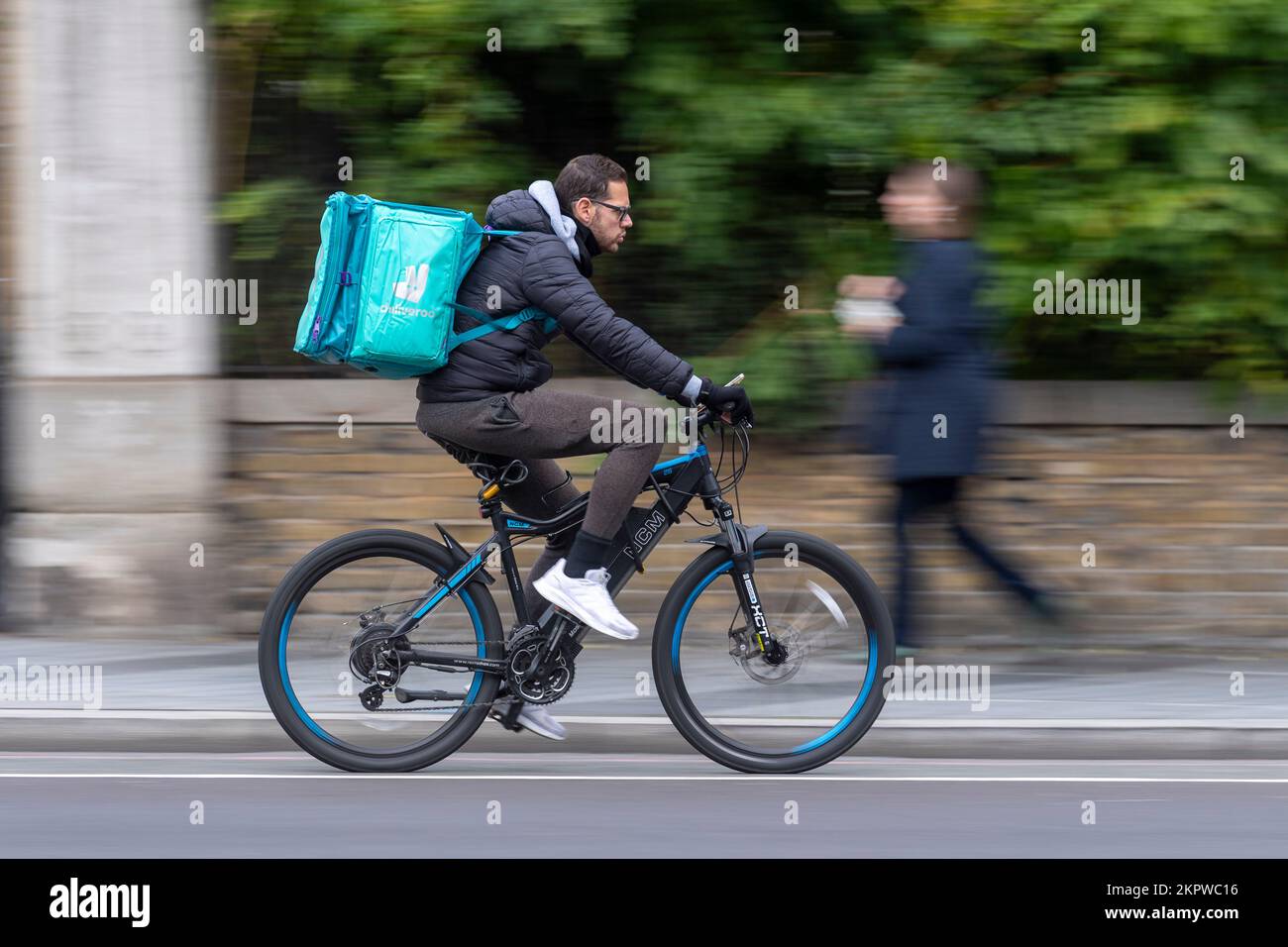 A deliveroo cycle courier riding an e-bike, Waterloo Road, London, UK ...