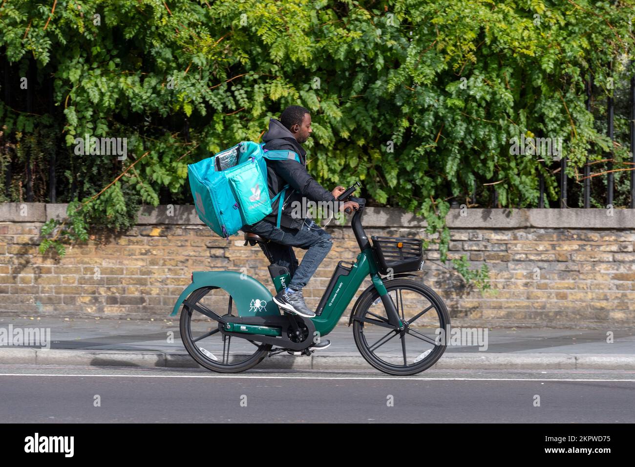 A deliveroo cycle courier riding an e-bike, Waterloo Road, London, UK ...