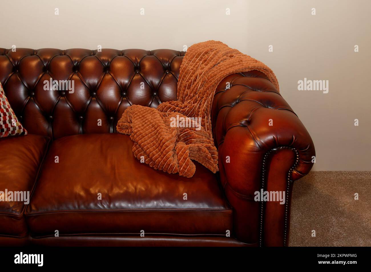 Half of retro shiny brown leather couch with blanket on a side Stock ...