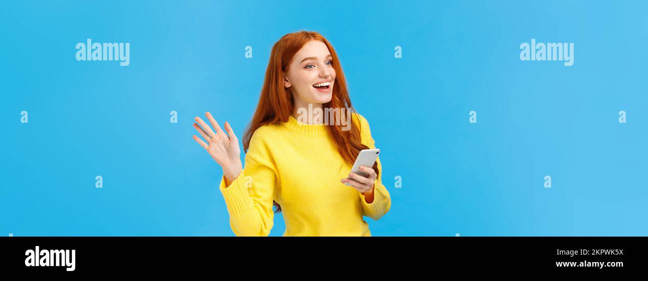 Cute and friendly, outgoing woman with red hair holding smartphone ...