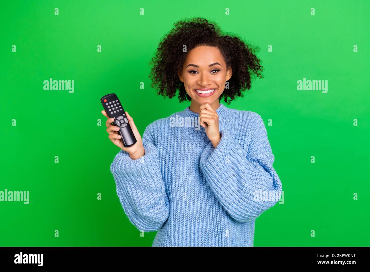 Photo of positive minded lady hand touch chin hold remote control ...