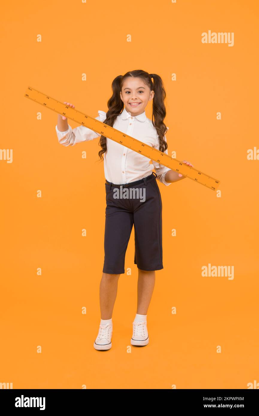 Learning geometry at school. Small school child holding measuring ...