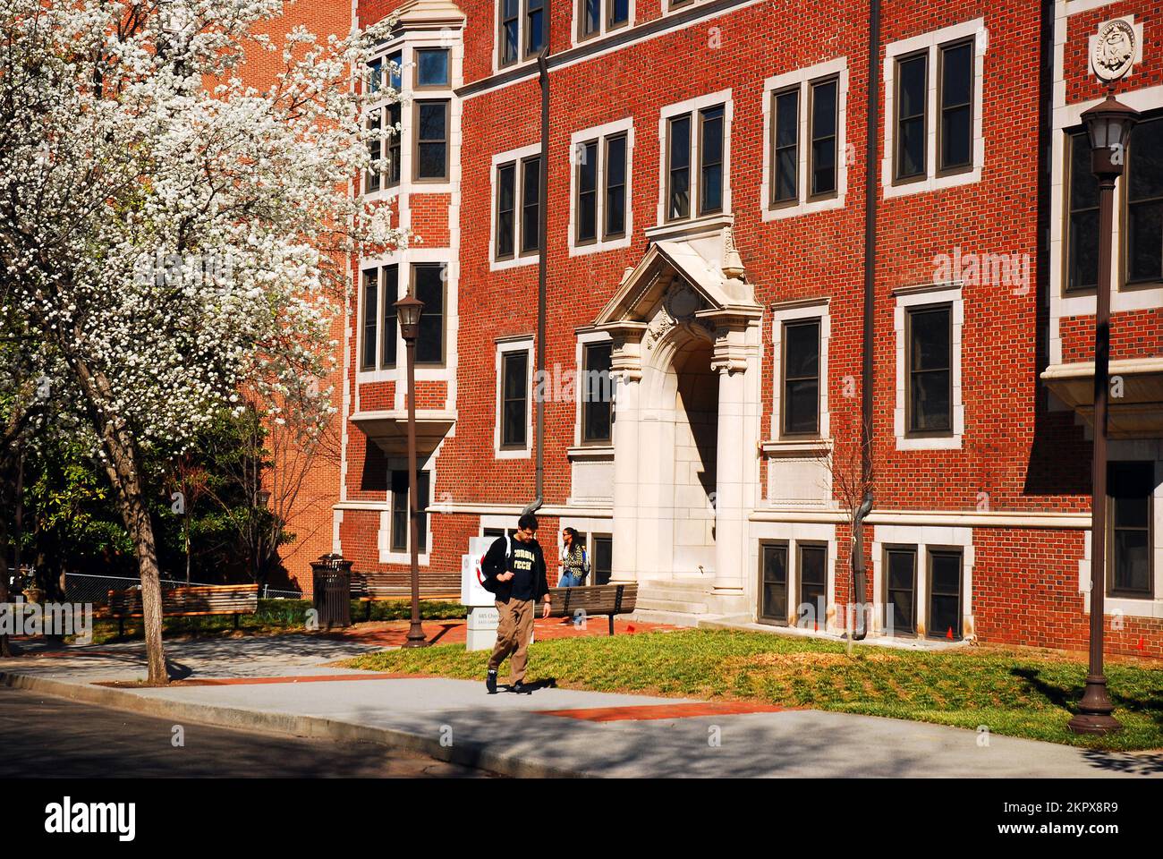 A student walks across the campus amongst the buildings of Georgia Tech ...