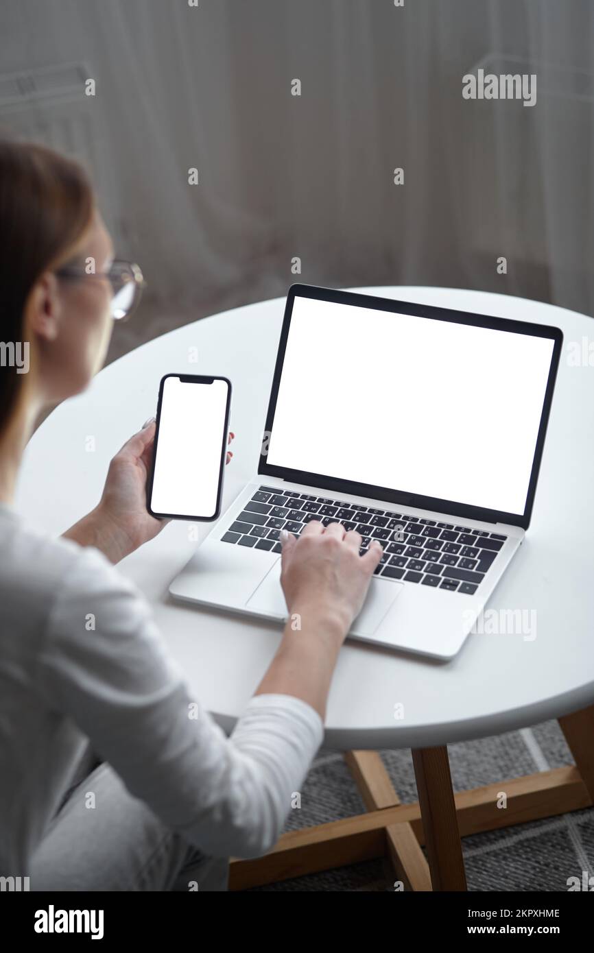 Mockup white screen laptop and mobile phone woman using computer while ...