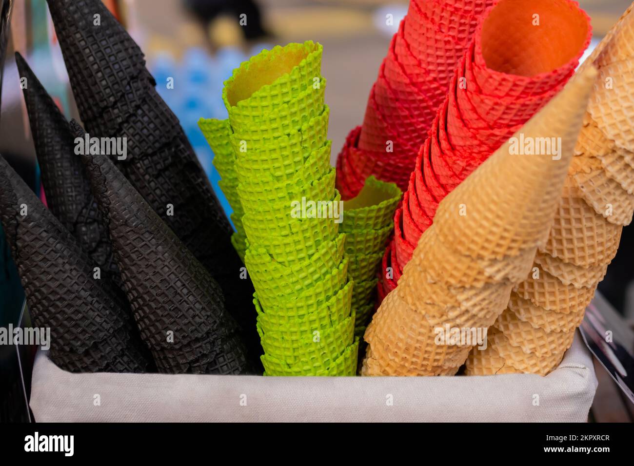 Stacks of many colorful empty waffle cones at outdoor food market ...