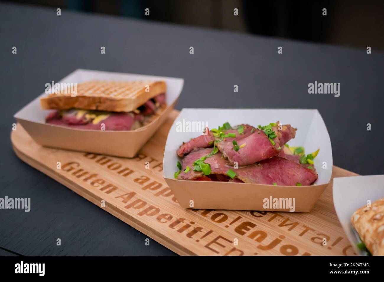 Fresh pastrami with spring onions in paper box at street food festival ...