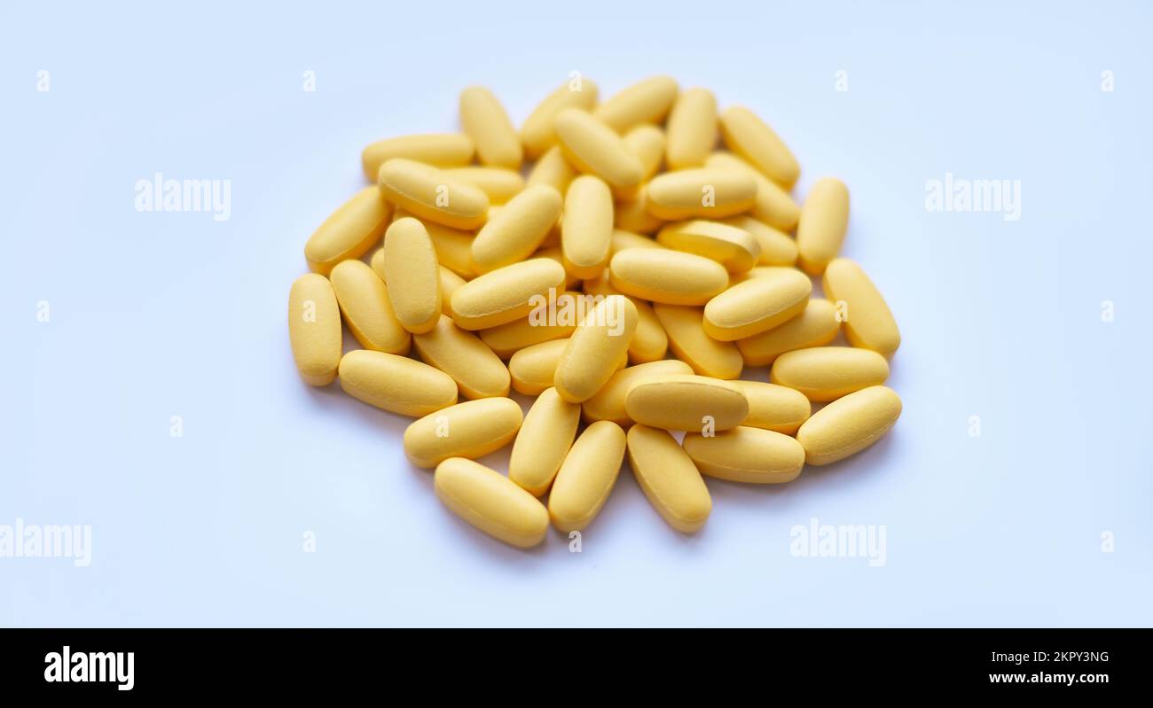 Close-up texture of yellow multivitamin tablets on white background ...