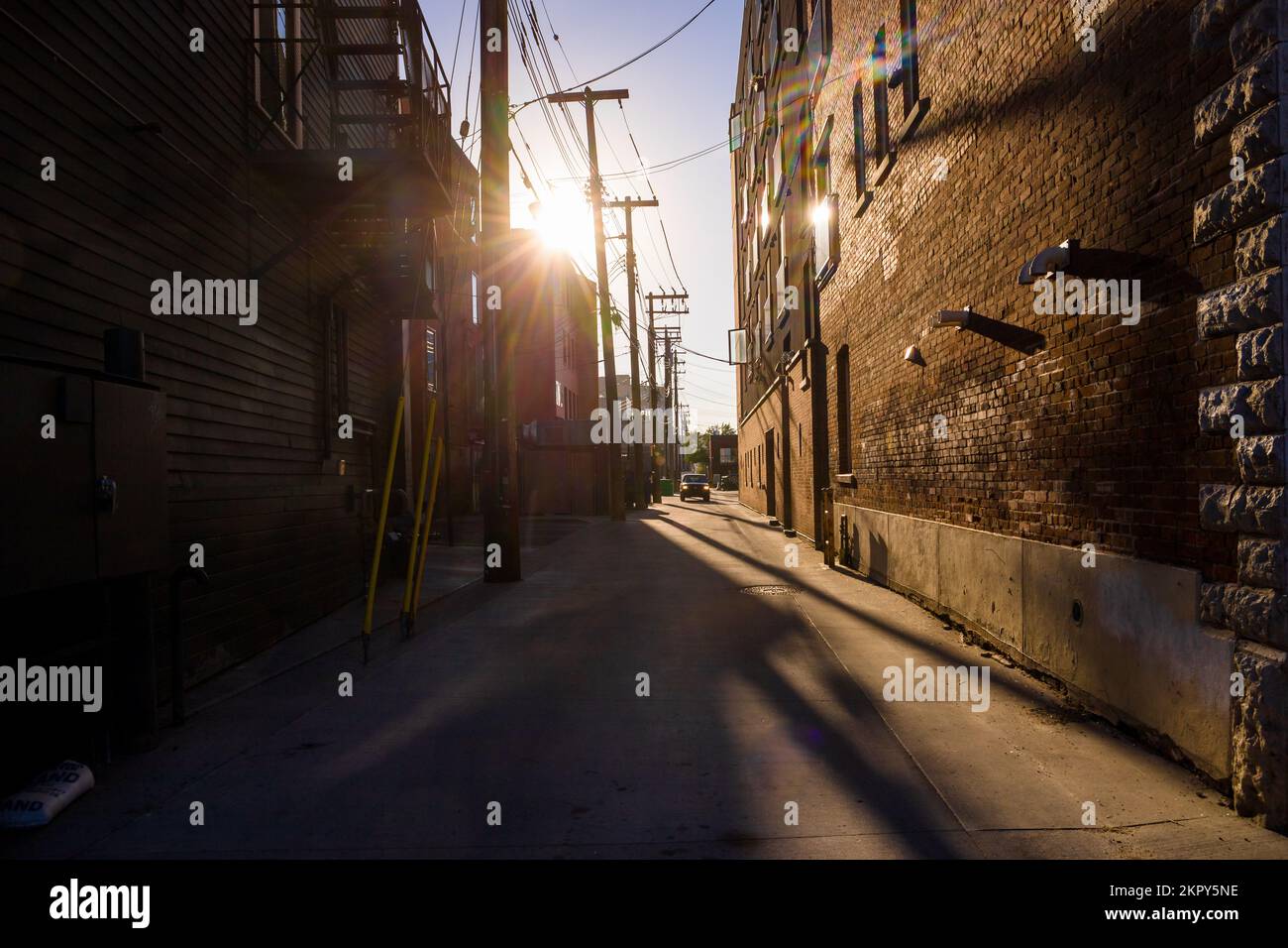 Sunset in the alley of old brick buildings - backyard, power lines ...