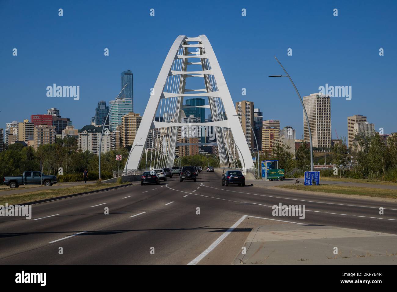 Modern arc bridge over the river, day traffic, summer time. modern ...