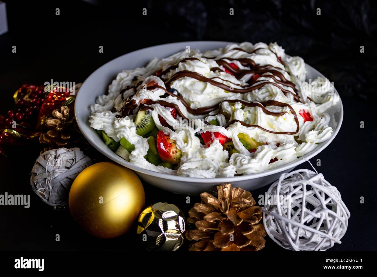 Fruit dessert with chocolate and cream topping in the bowl, Christmas ...