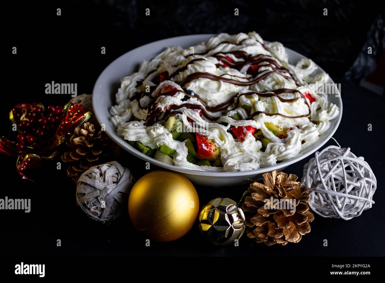 Fruit dessert with chocolate and cream topping in the bowl, Christmas ...
