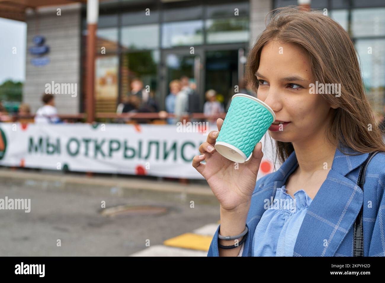 KALININGRAD, RUSSIA - CIRCA JULY, 2022: teenager with paper cup from fast food restaurant Vkusno ...