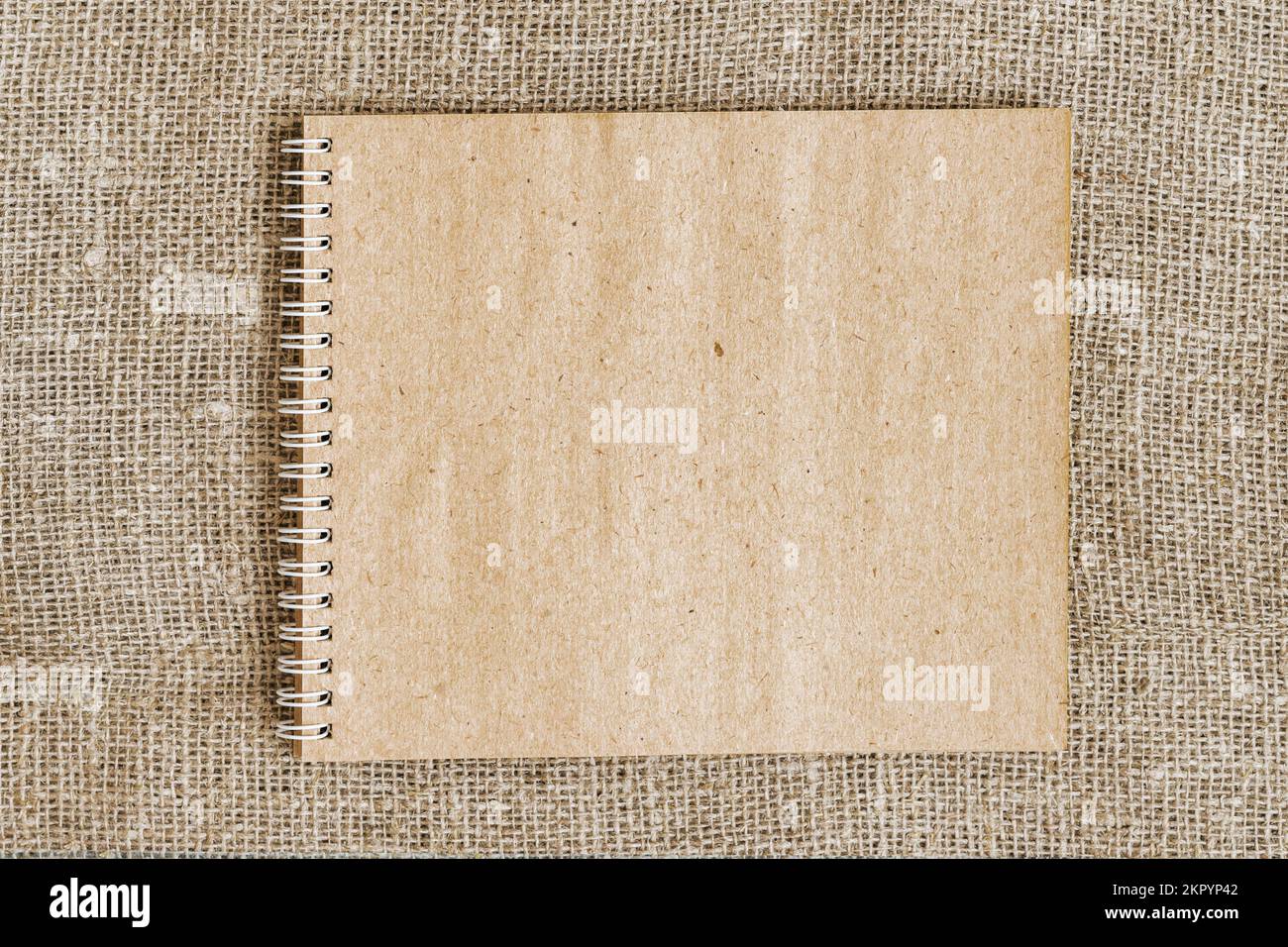 Open sketchbook with craft paper on spiral, vintage background of sack ...
