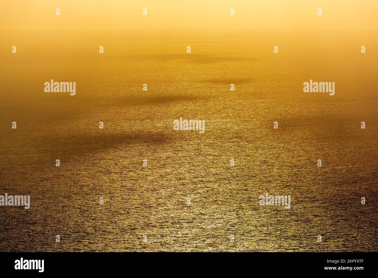 Surface water background of the ocean at sunset with a golden light ...