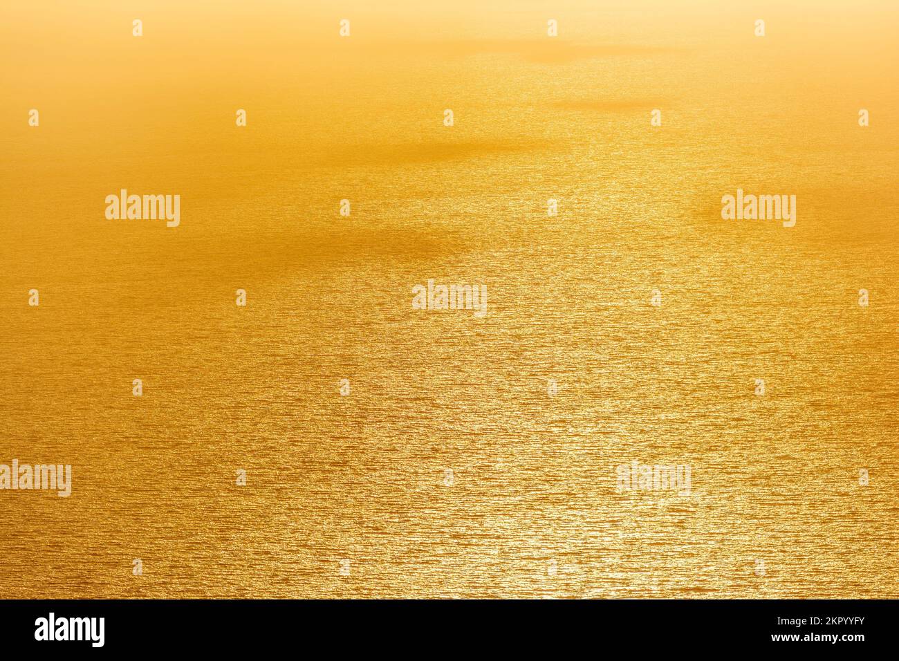 Surface water background of the ocean at sunset with a golden light ...