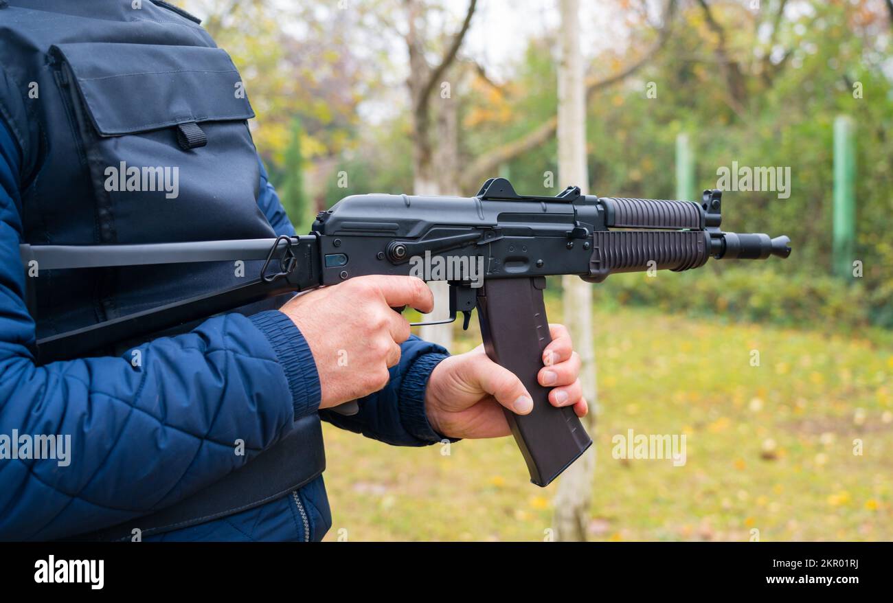 A man holds a Kalashnikov assault rifle in his hands side view Stock ...
