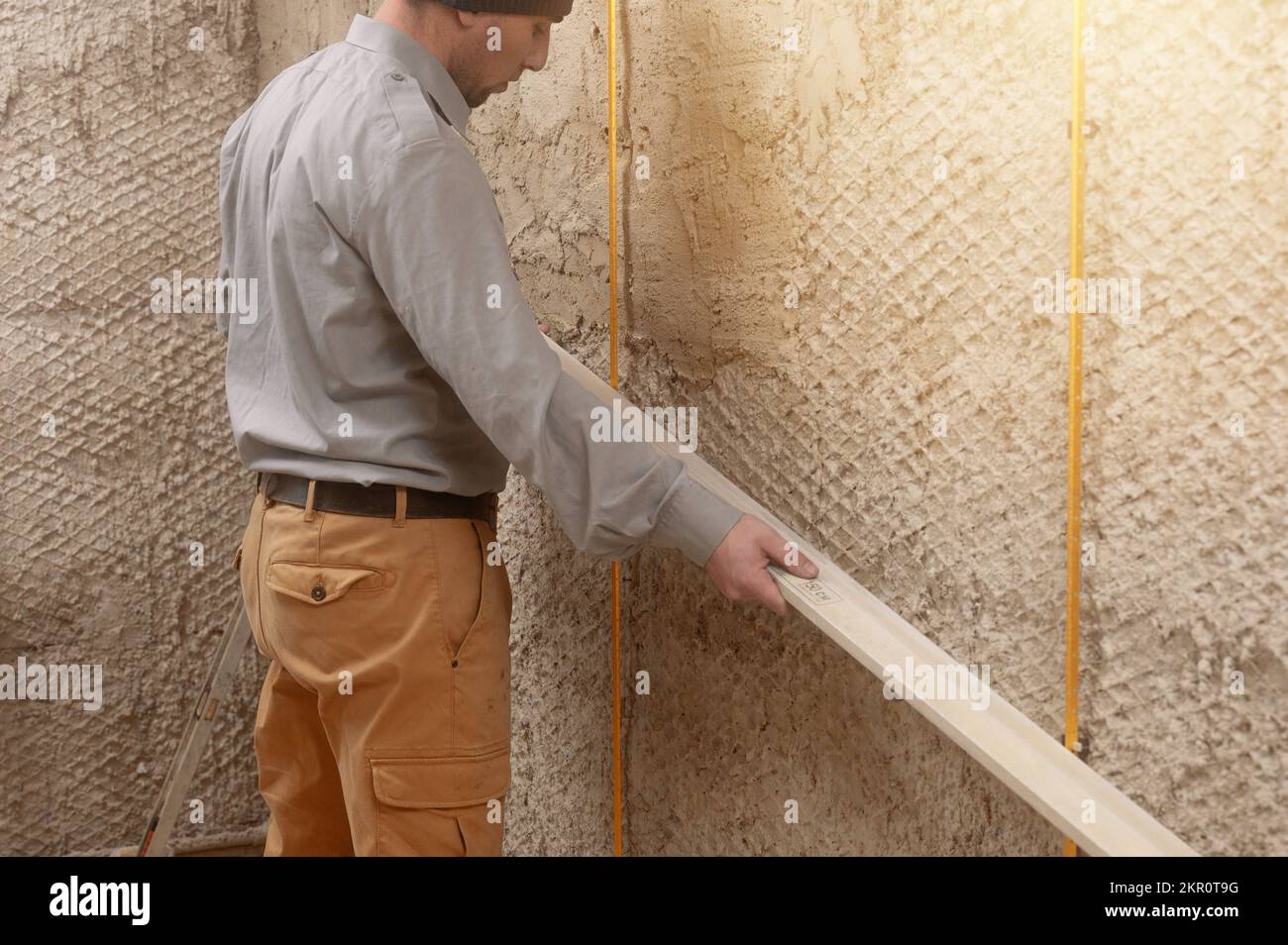 metal guide beacons are attached to the wall, the master checks the ...
