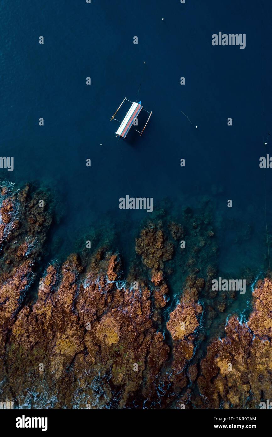Aerial view of banca boat near rocky coastline Stock Photo - Alamy
