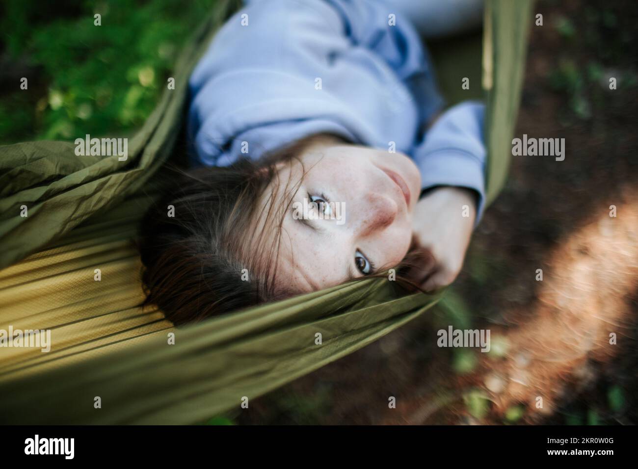 Teen girl laying in a hammock outside Stock Photo - Alamy