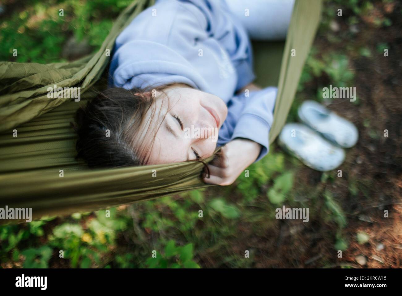 Teen girl laying in hammock smiling Stock Photo - Alamy