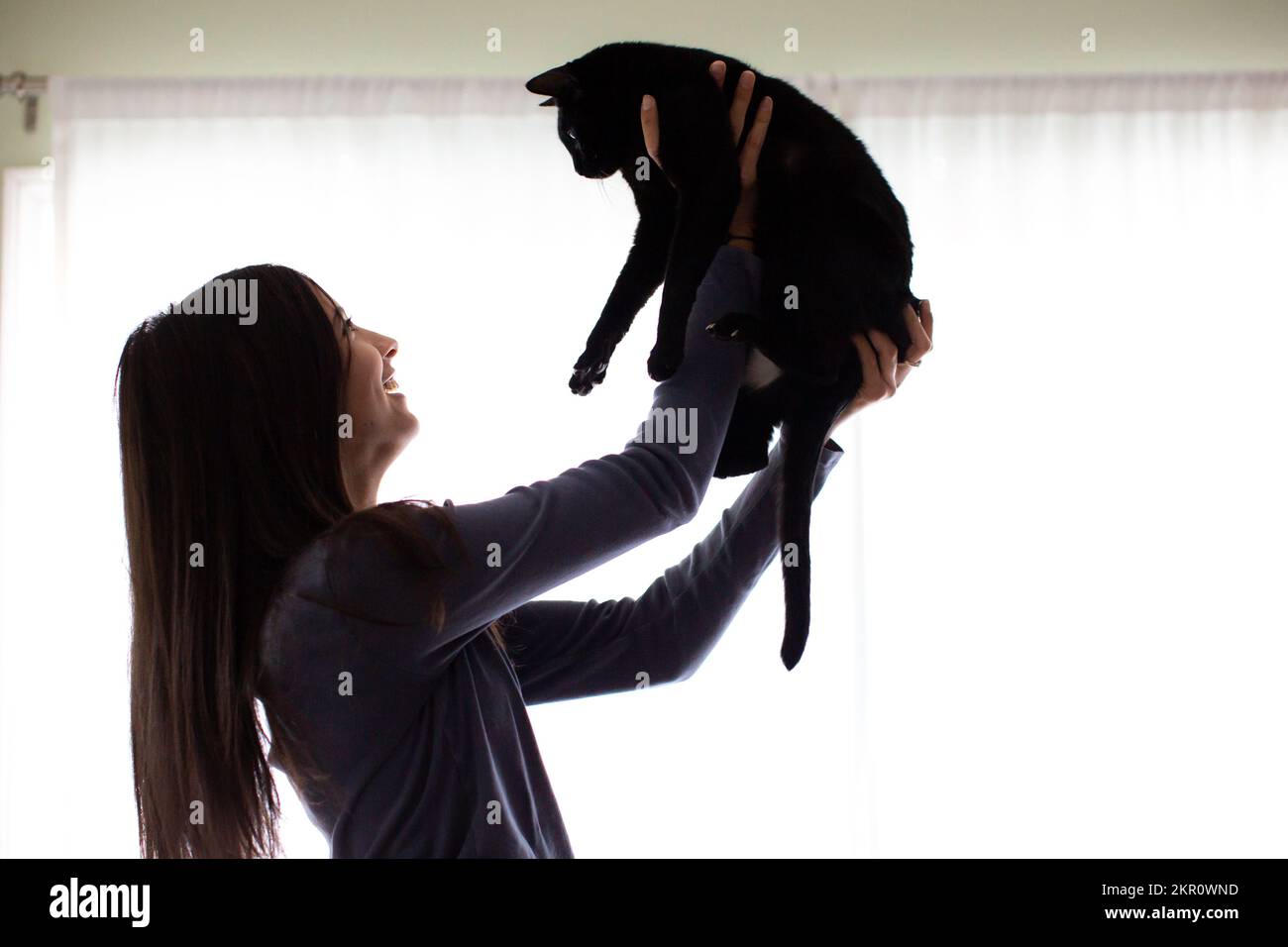 Teen Girl Holds Black Cat Up And Smiles Stock Photo - Alamy