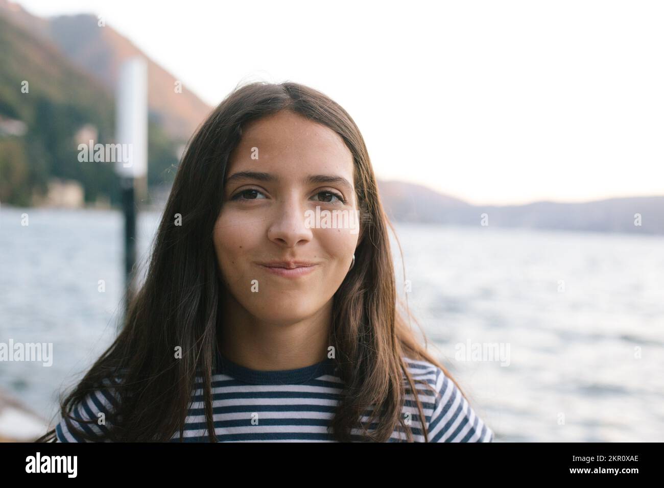 Teen Girl About To Crack A Smile In Front Of Lake Como Stock Photo - Alamy