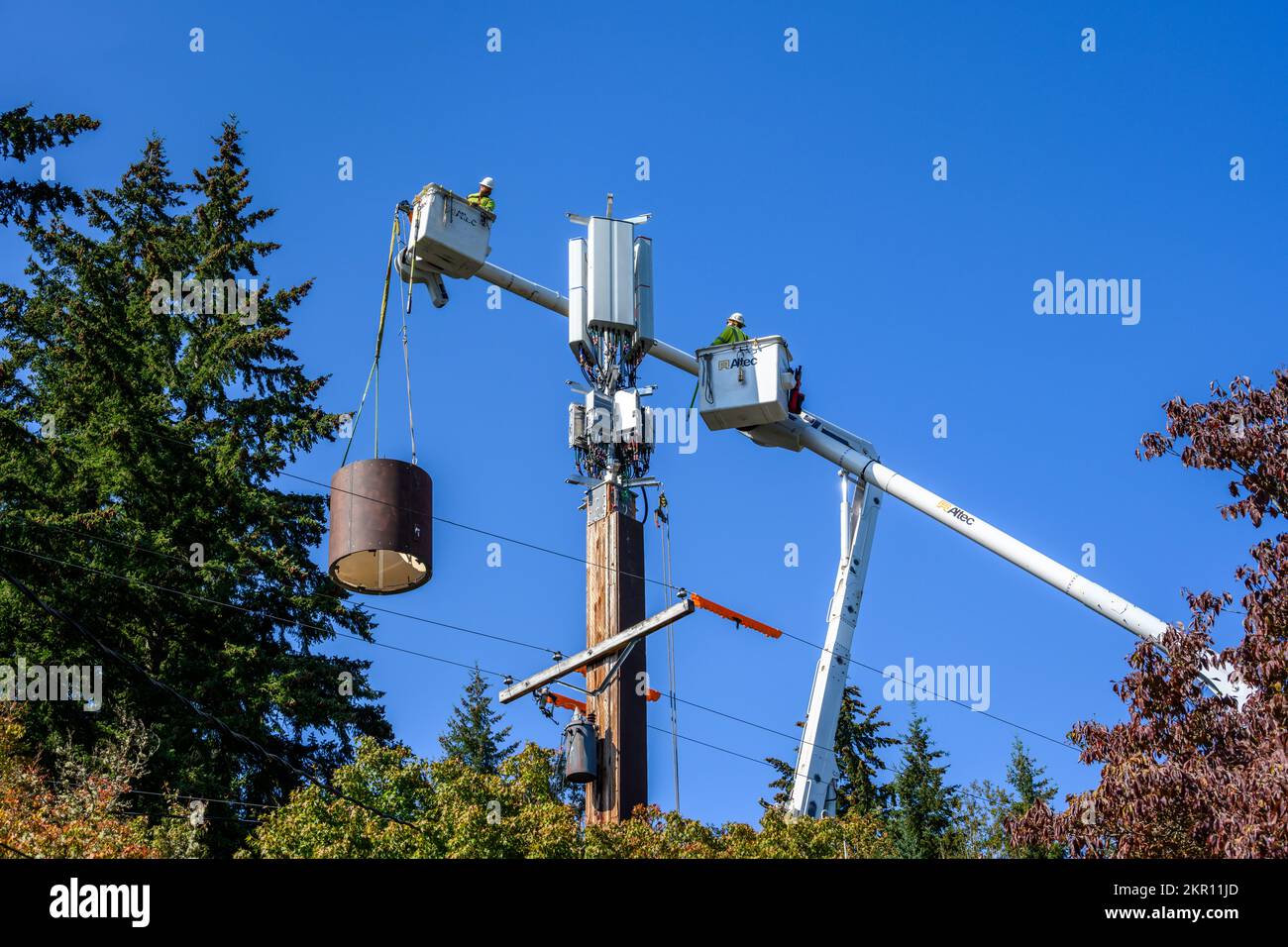 BELLEVUE, WA, USA – SEPTEMBER 30, 2022: two linemen up in the air ...