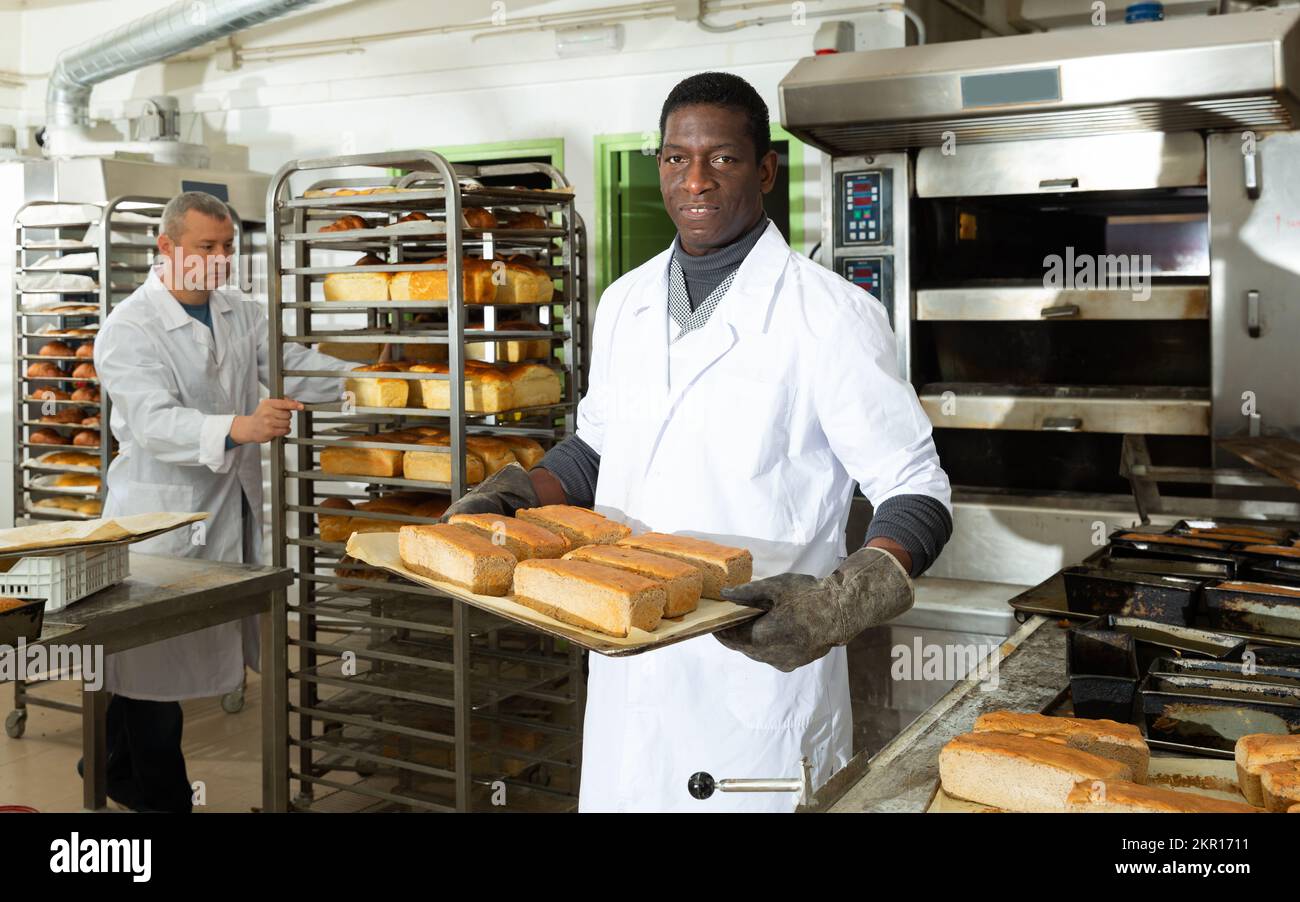 African baker carrying baked bread on tray Stock Photo - Alamy