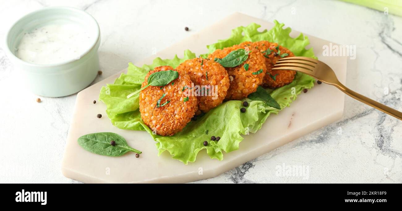 Board with tasty lentil cutlets on white table Stock Photo - Alamy