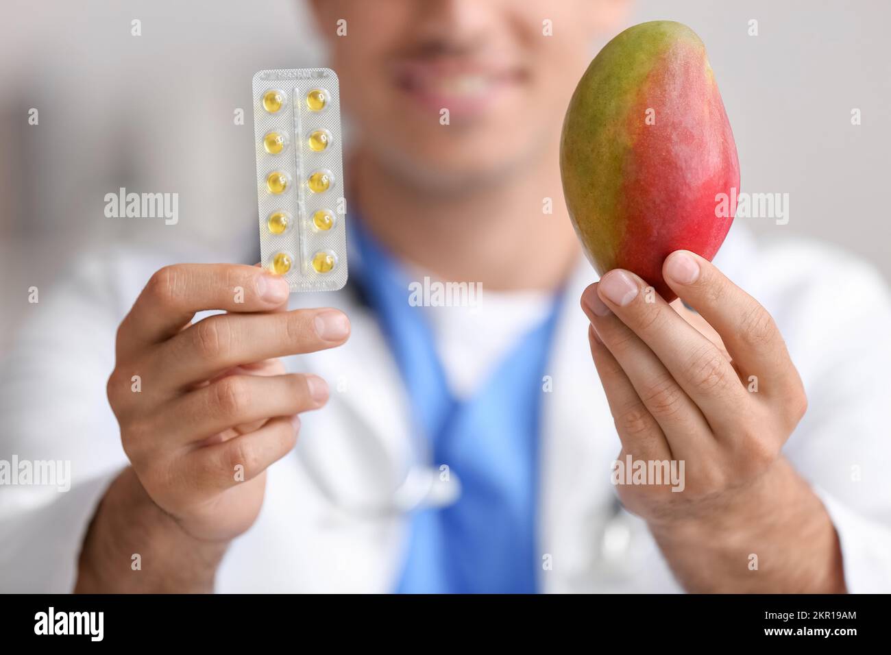 Male doctor with vitamins and mango in clinic, closeup Stock Photo - Alamy