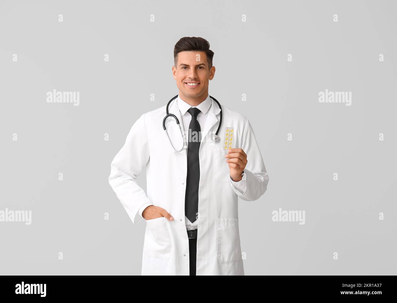 Male doctor with vitamins on light background Stock Photo - Alamy